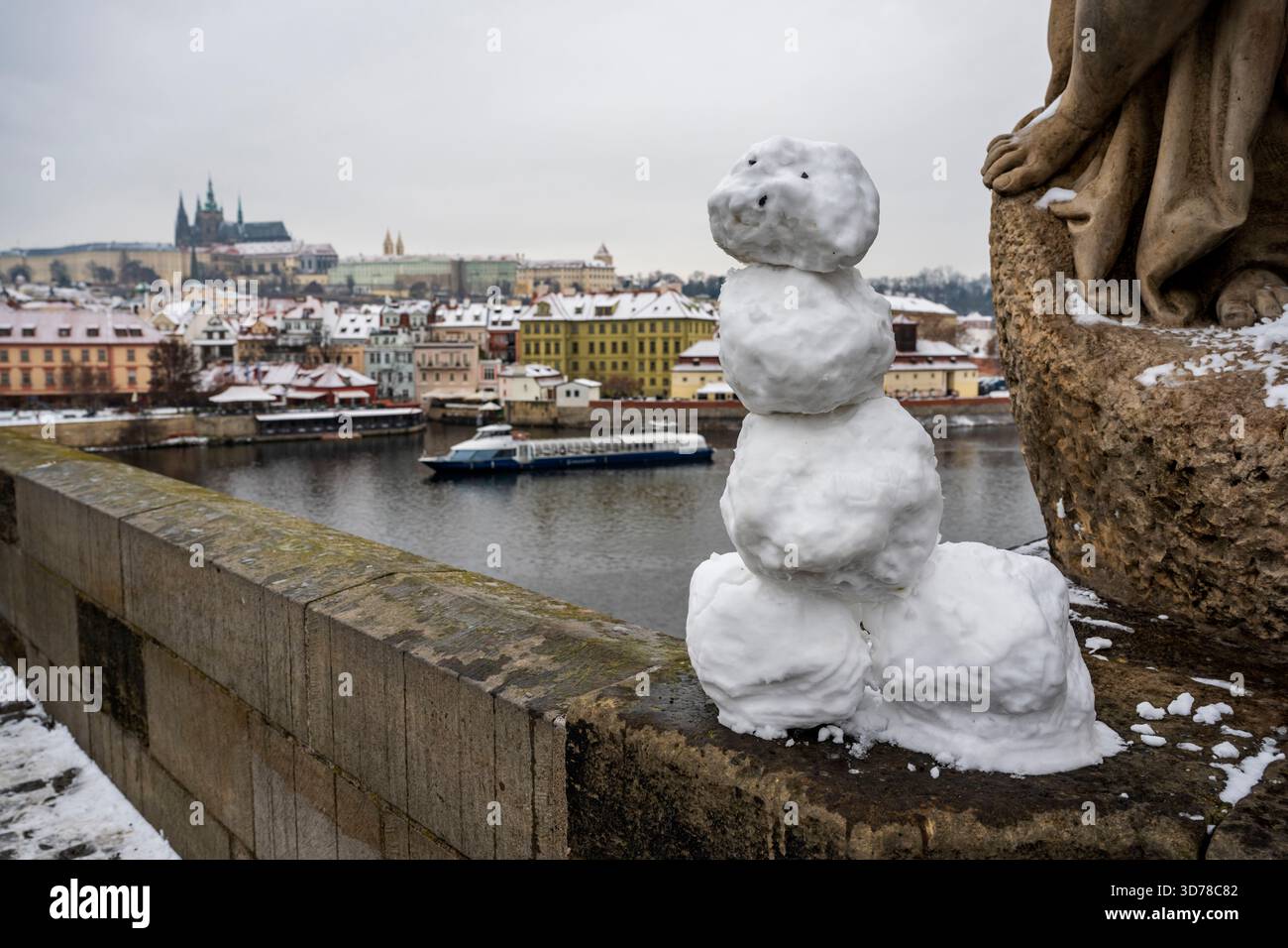 A snowman on the Charles Bridge with Prague Castle in the background ...