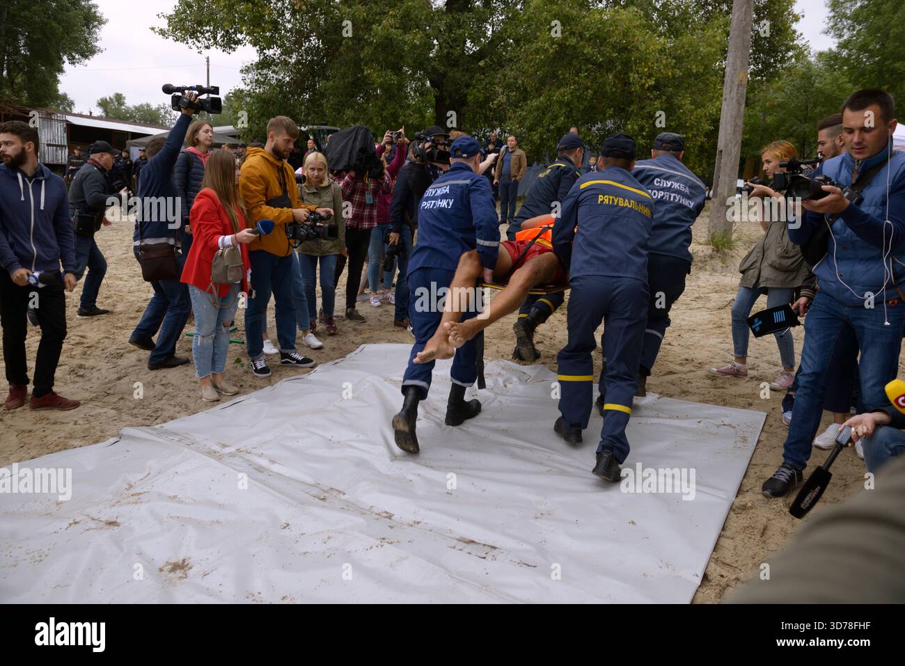 Rescuers team carrying sufferer on a stretcher helping him to get to ...