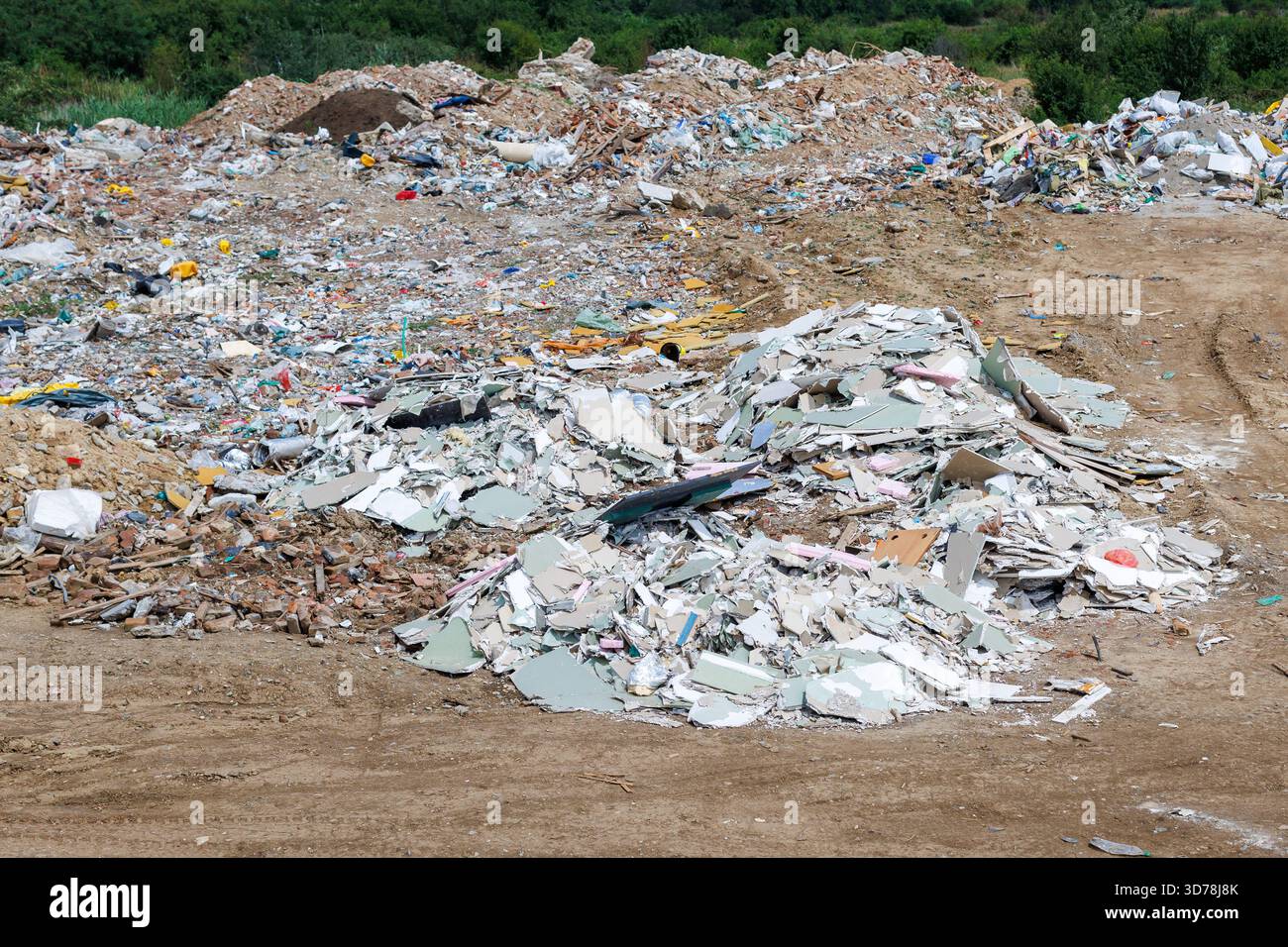 Construction debris pile at a disposal site with scattered waste ...
