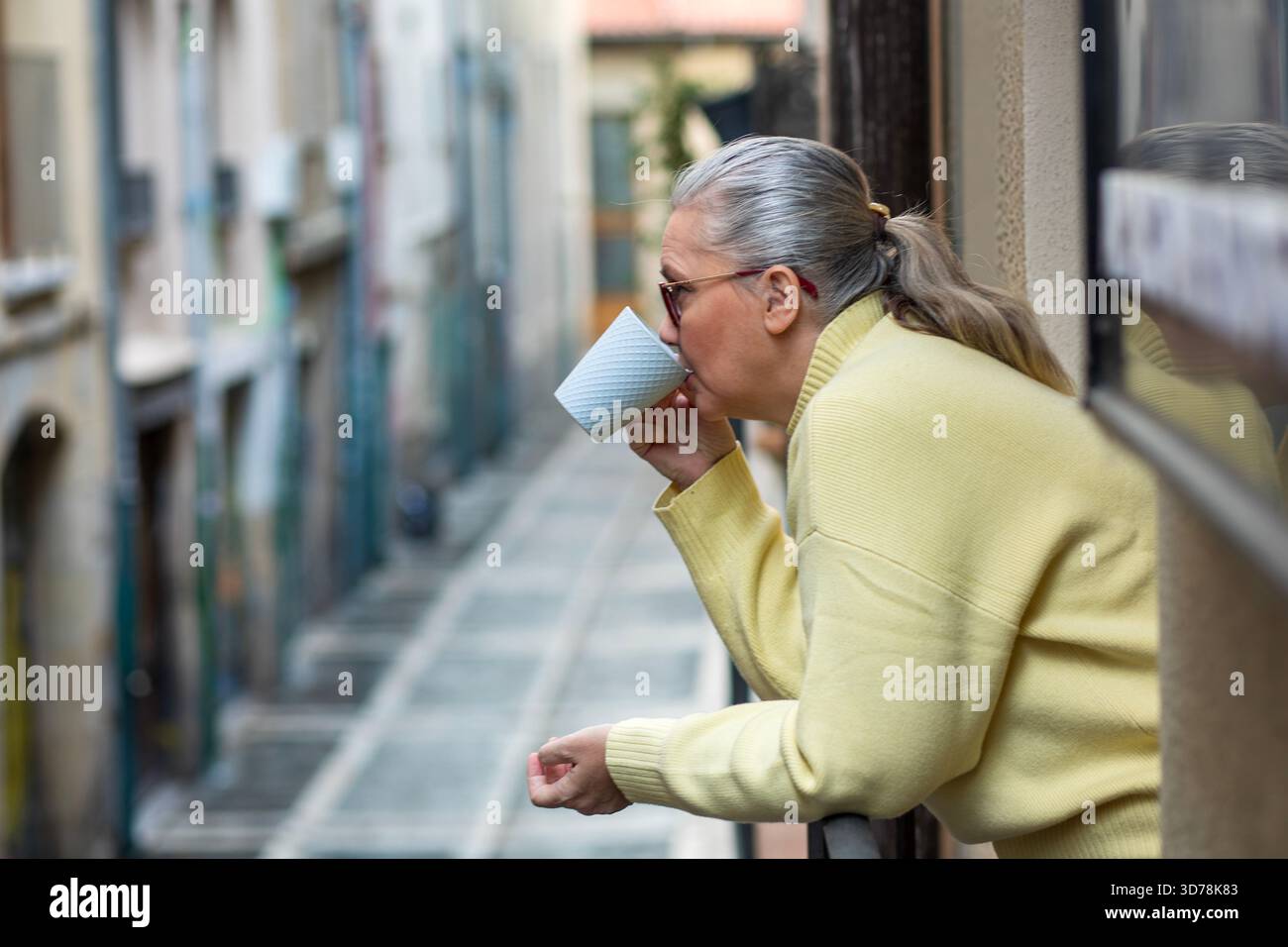 Woman leans against balcony hi-res stock photography and images - Alamy