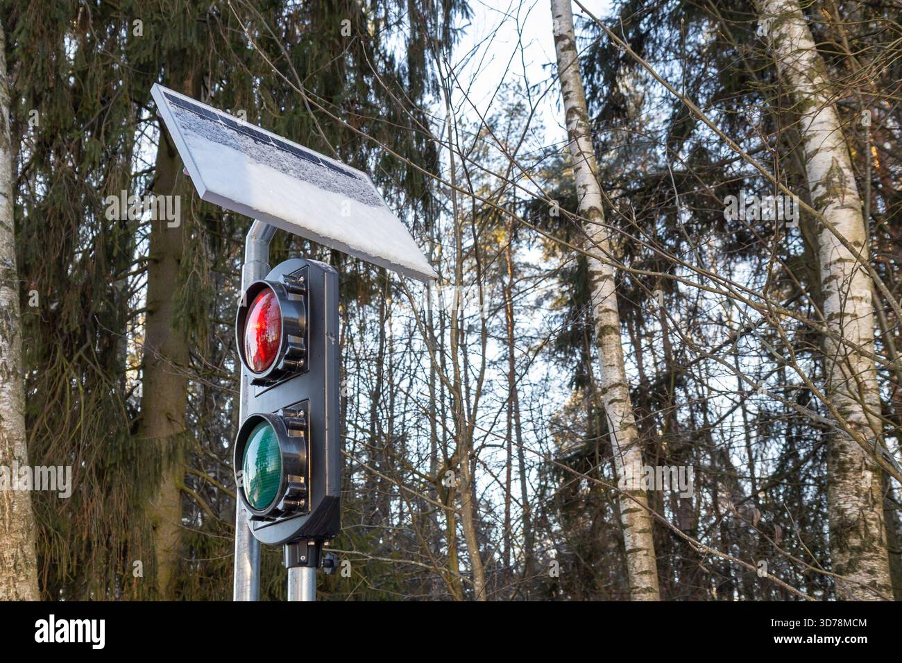 Traffic light mounted on a pole powered by solar panels. Outdoor road ...