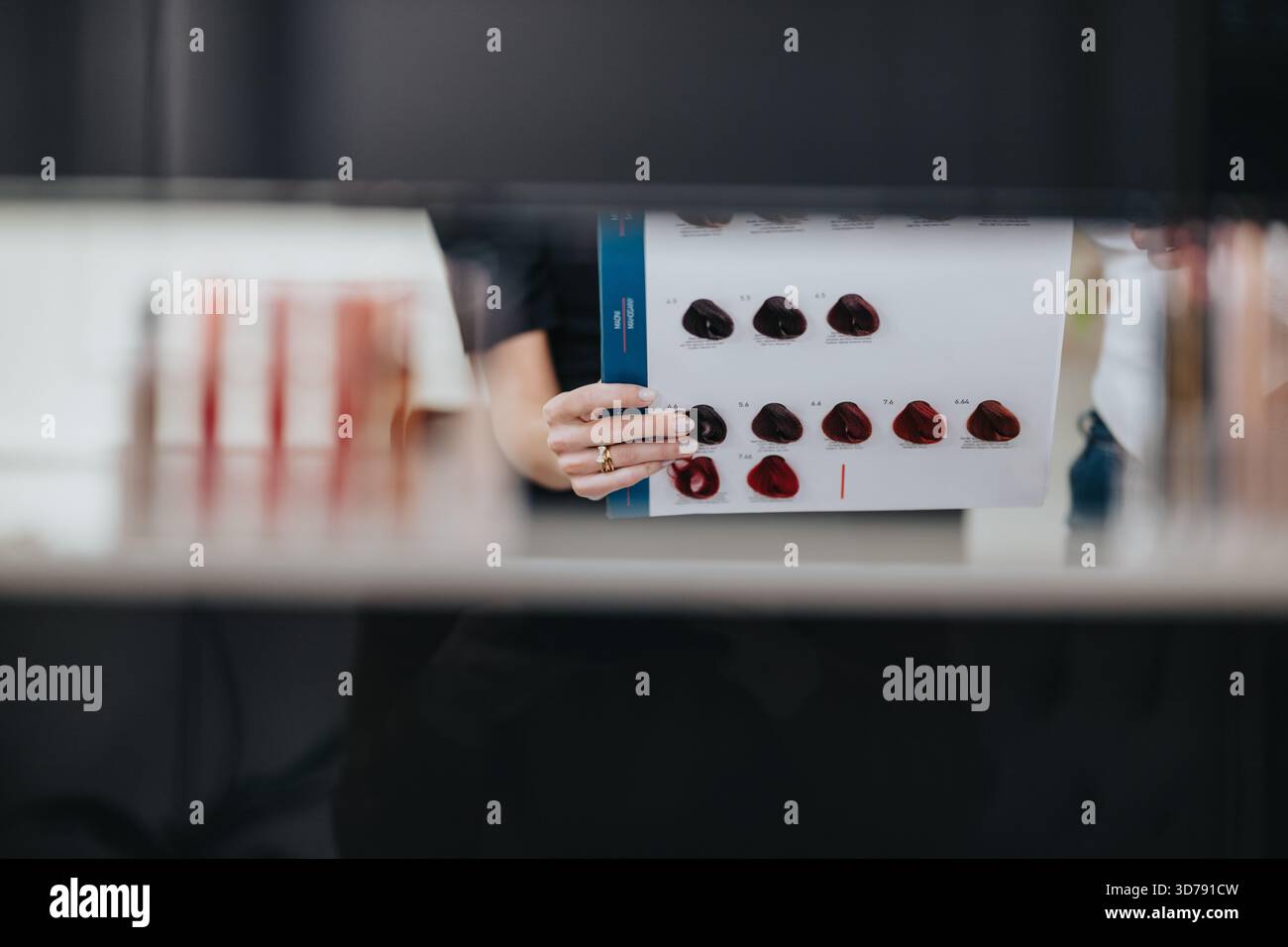 Person holds hair color chart in a salon, showcasing various shade ...