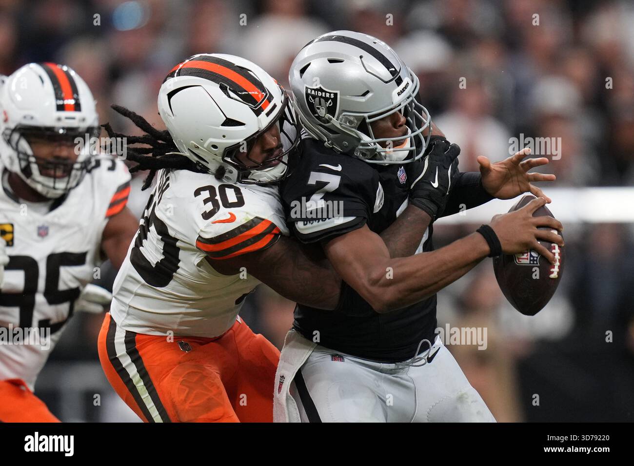 Las Vegas Raiders quarterback Geno Smith (7) is hit by Cleveland Browns ...