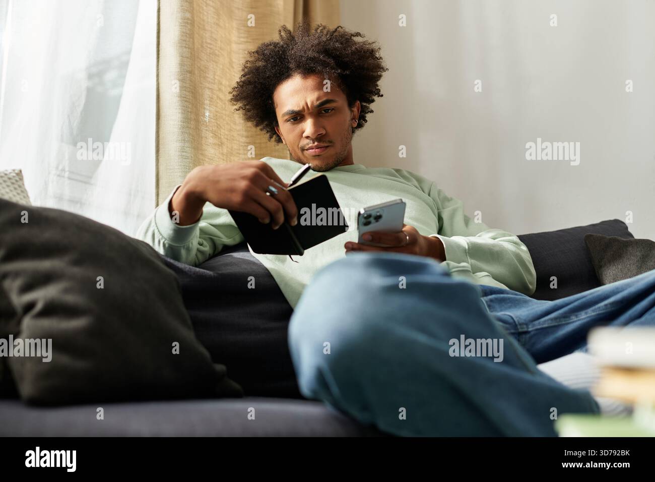 Handsome african man sits hi-res stock photography and images - Alamy