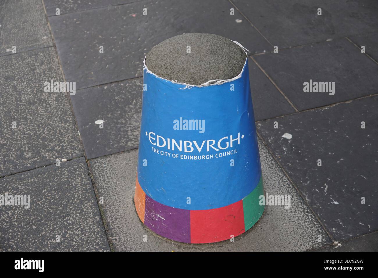 Street cone covered with an Edinburgh City Council wrap on a pavement ...