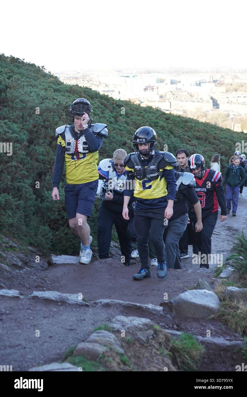 American football players in full gear hiking up a trail at Arthur’s ...