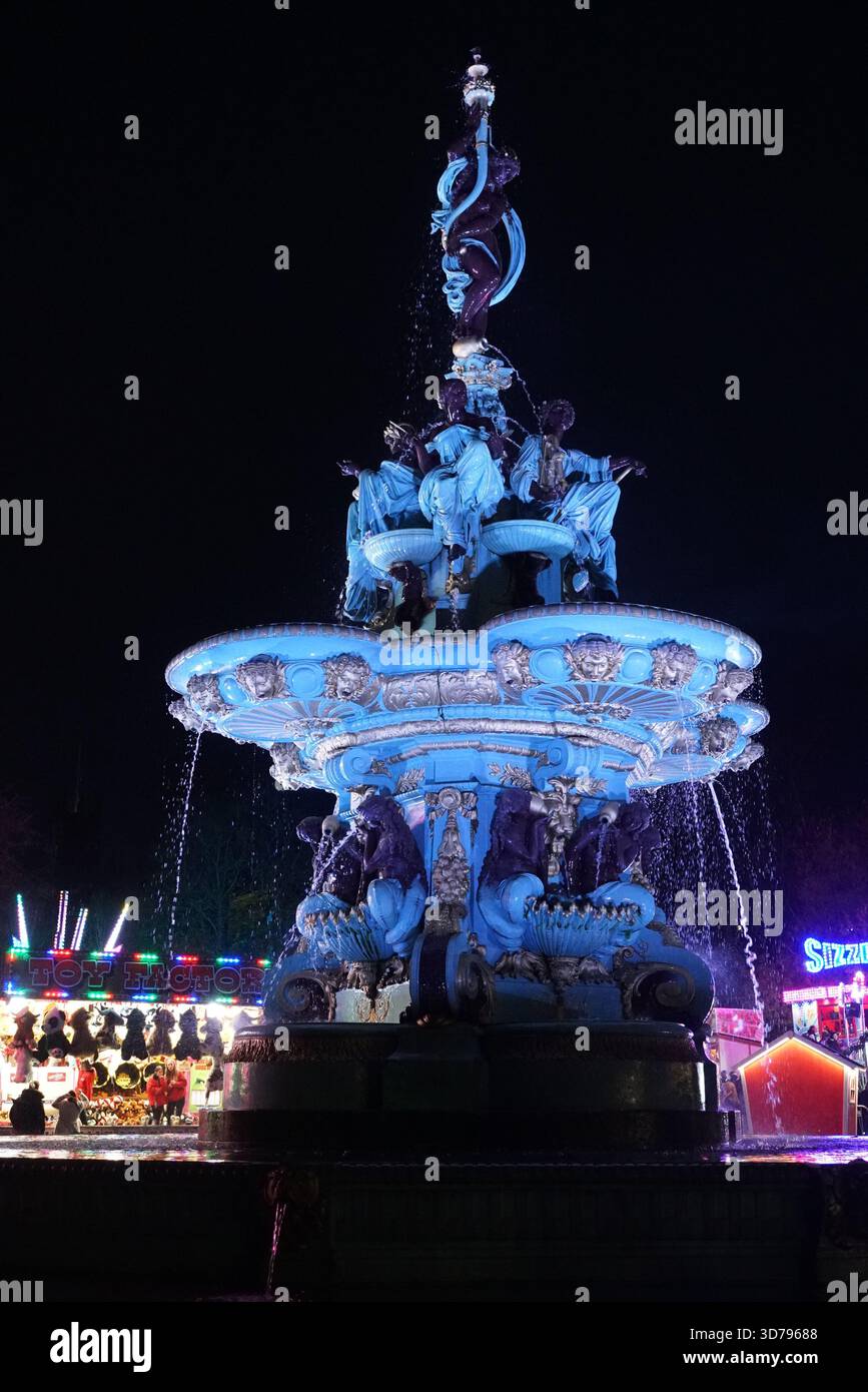 The illuminated Ross Fountain glows in blue light during a winter night ...