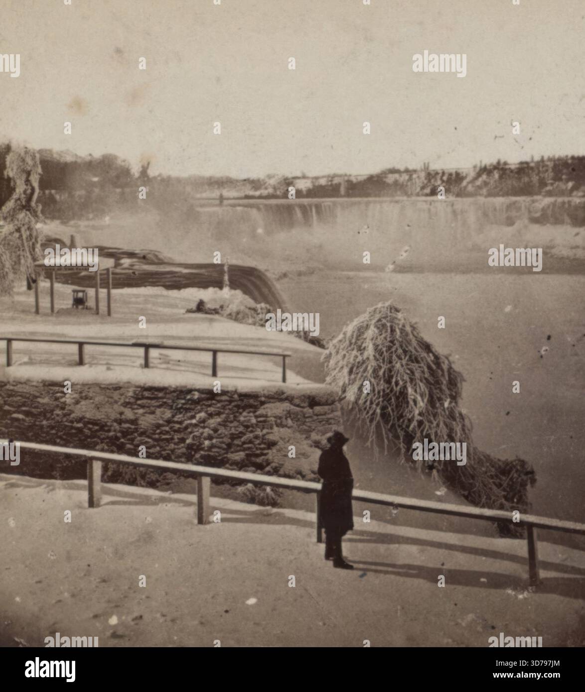 A winter scene at Niagara Falls featuring a man looking out from a ...