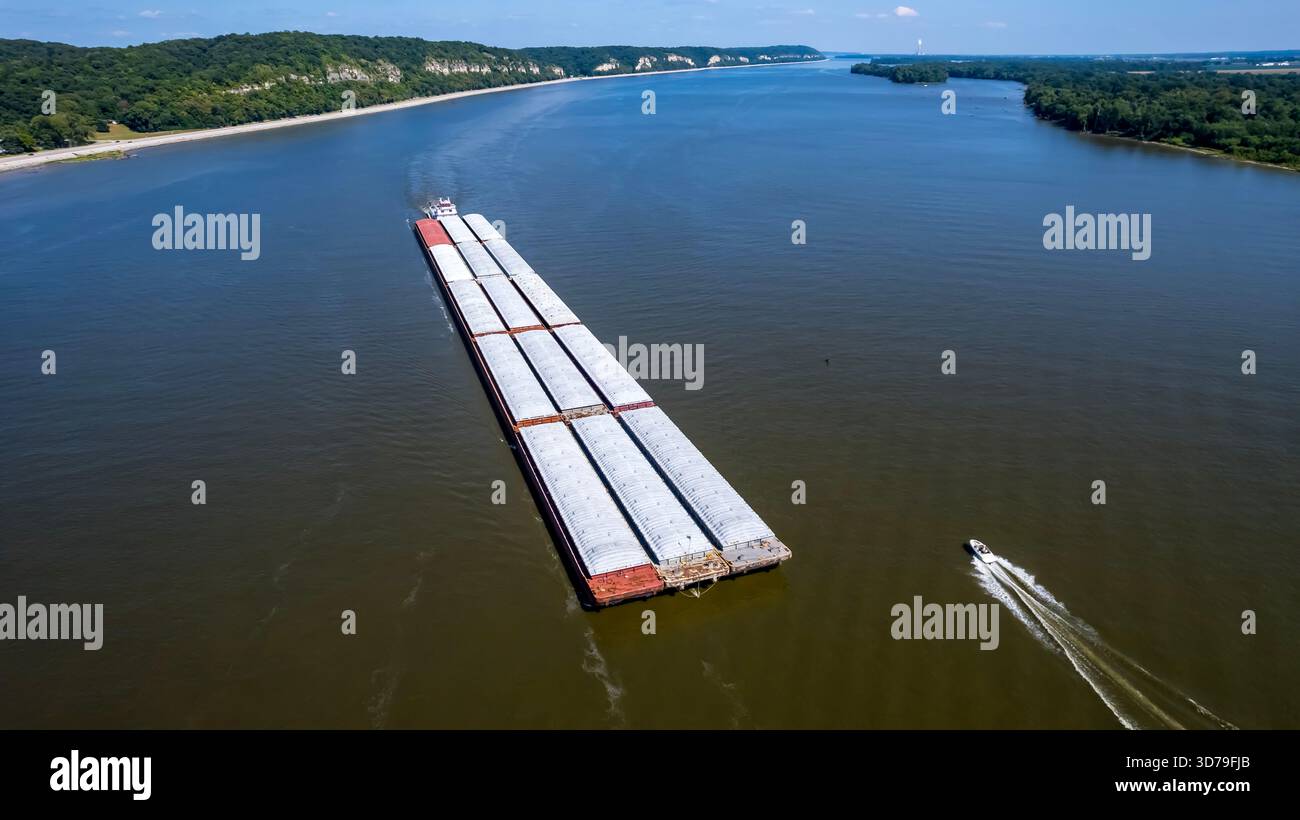 Aerial view of a barge pushing cargo down the winding Mississippi River ...