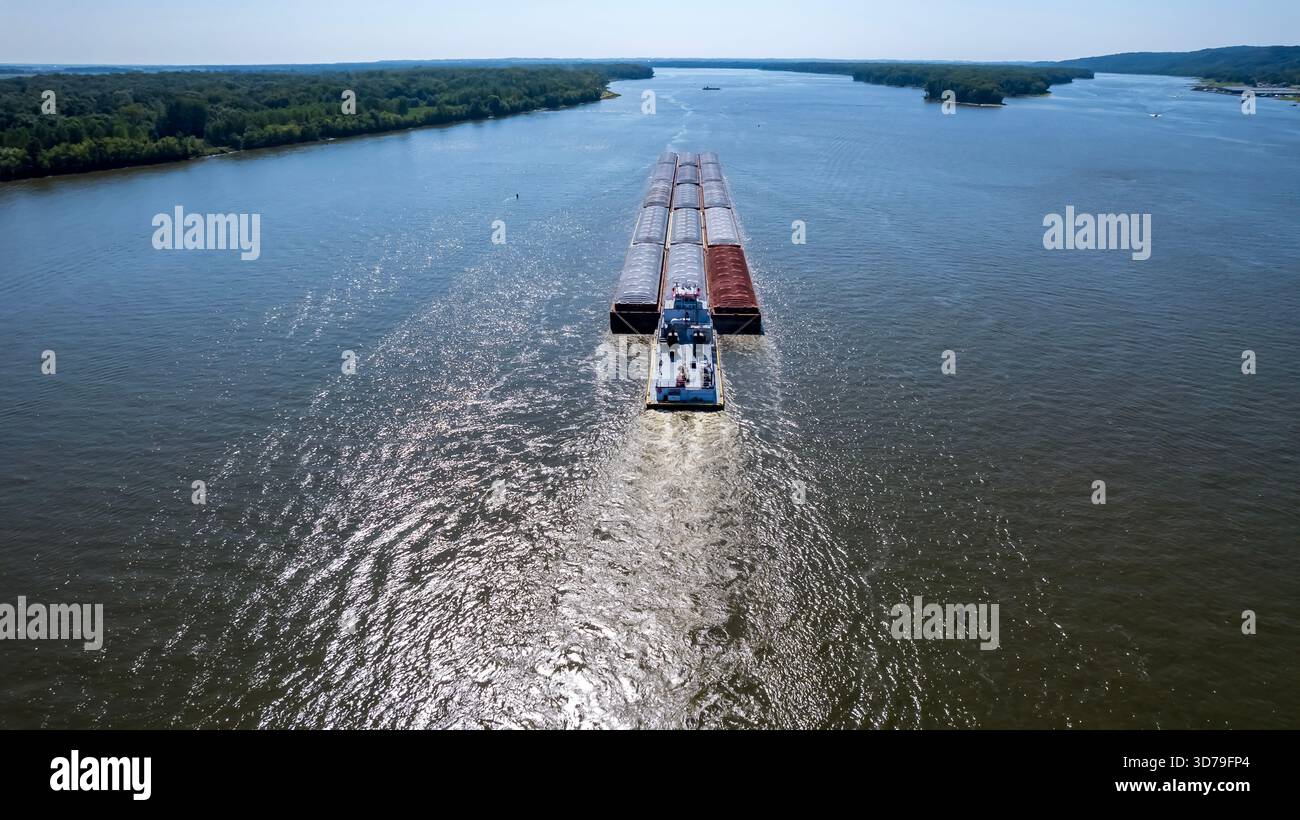 Aerial view of a barge pushing cargo down the winding Mississippi River ...