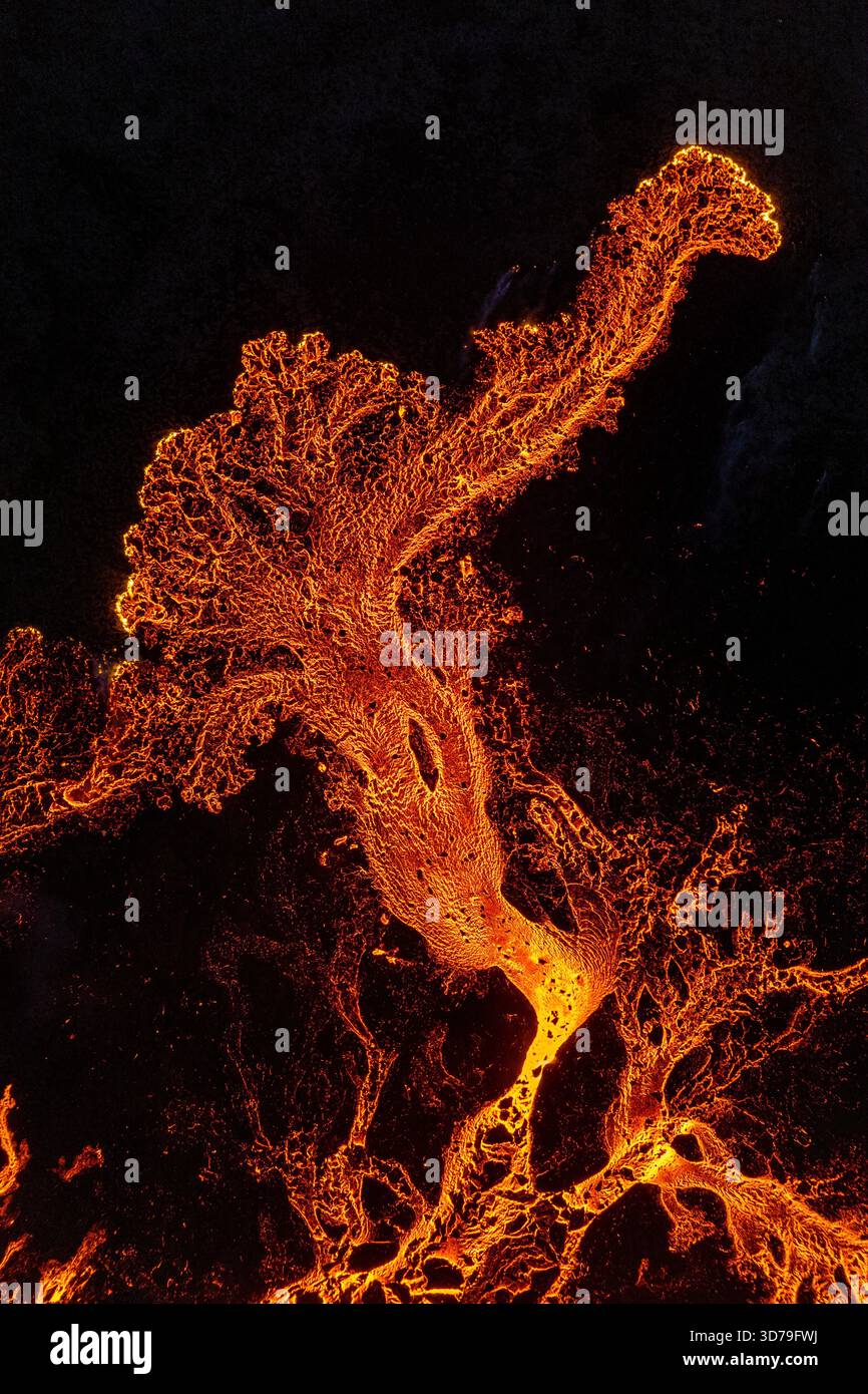 Aerial view of fiery rivers of molten lava snake across the dark earth ...