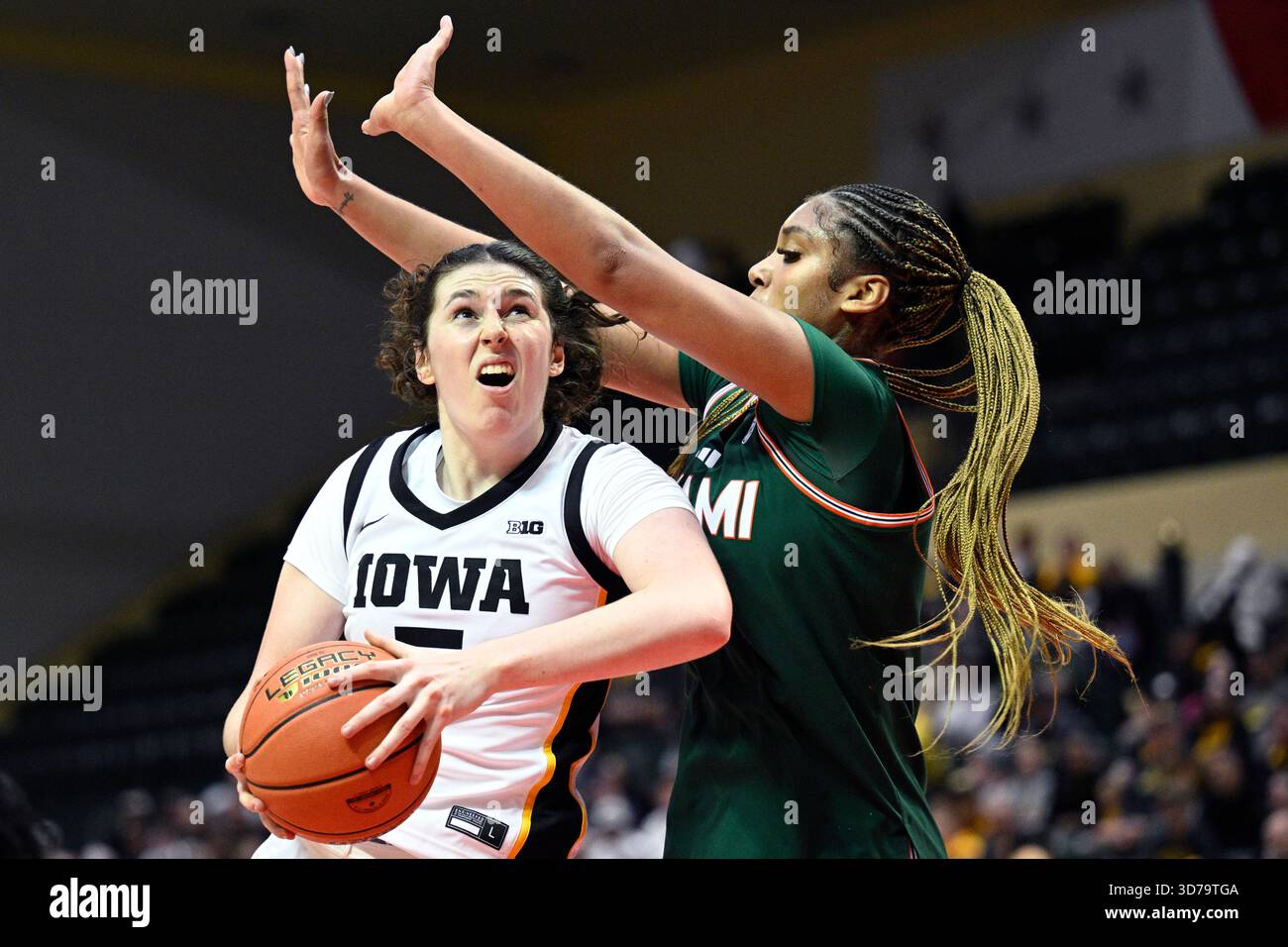 Iowa center Ava Heiden (5) goes up to shoot while defended by Miami ...