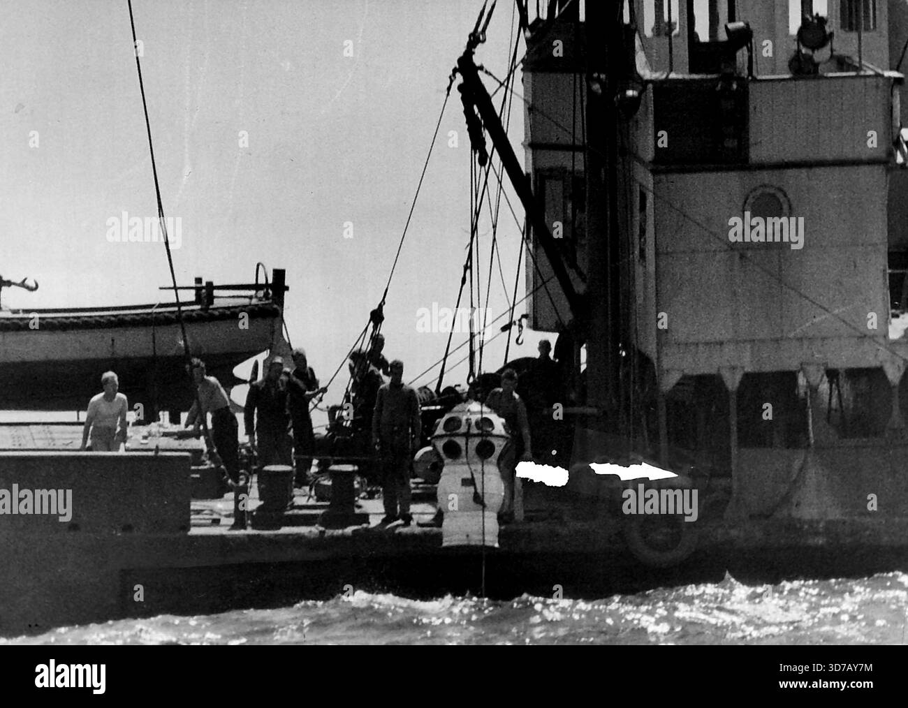 Lower: Diver Frank Higgins is lowered from Foremost 17 in diving bell ...