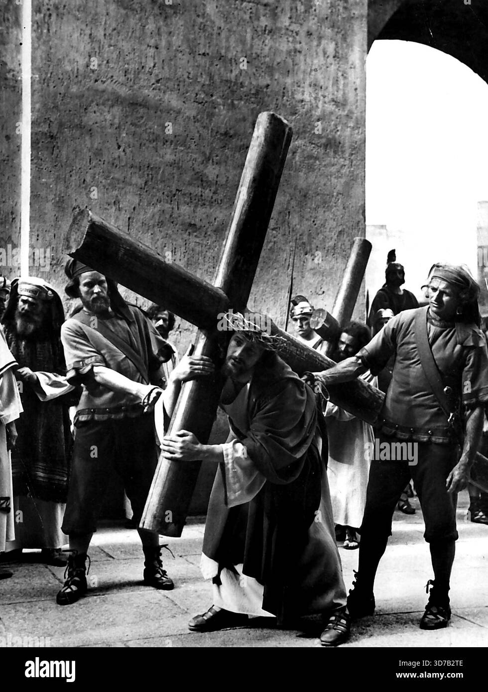 Wearing his crown of thorns, Jesus carries the cross to Golgatha as the ...