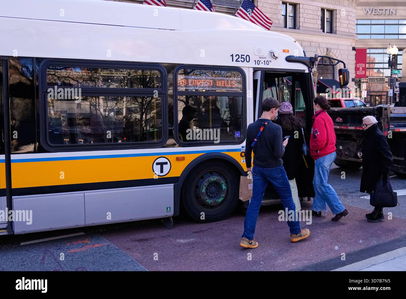 Commuters load onto a Massachusetts Bay Transportation Authority bus ...