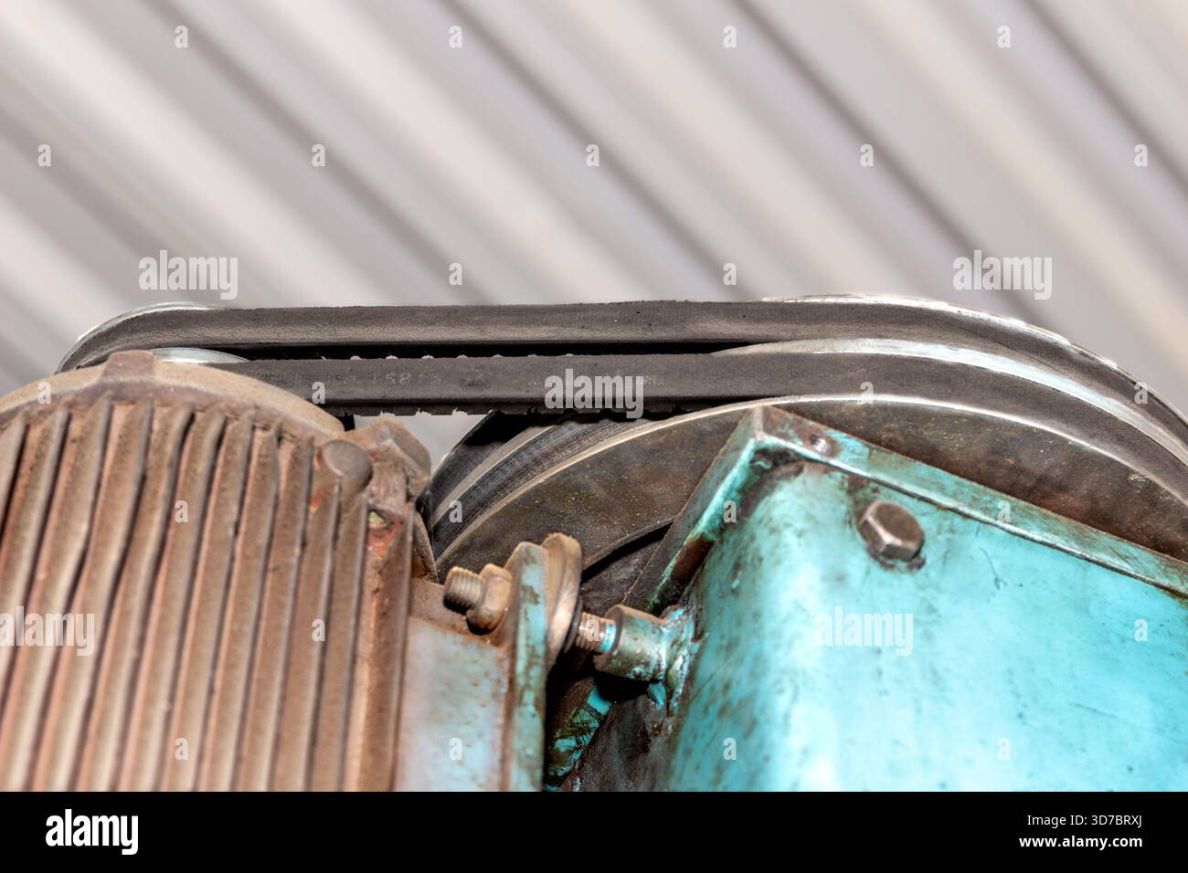 Close-up of two tensioned belts looping between motor and machine ...