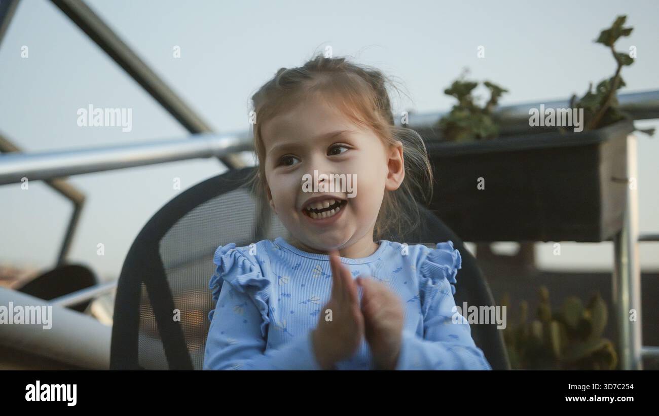 Happy child clapping hands outdoors in evening light Stock Photo - Alamy