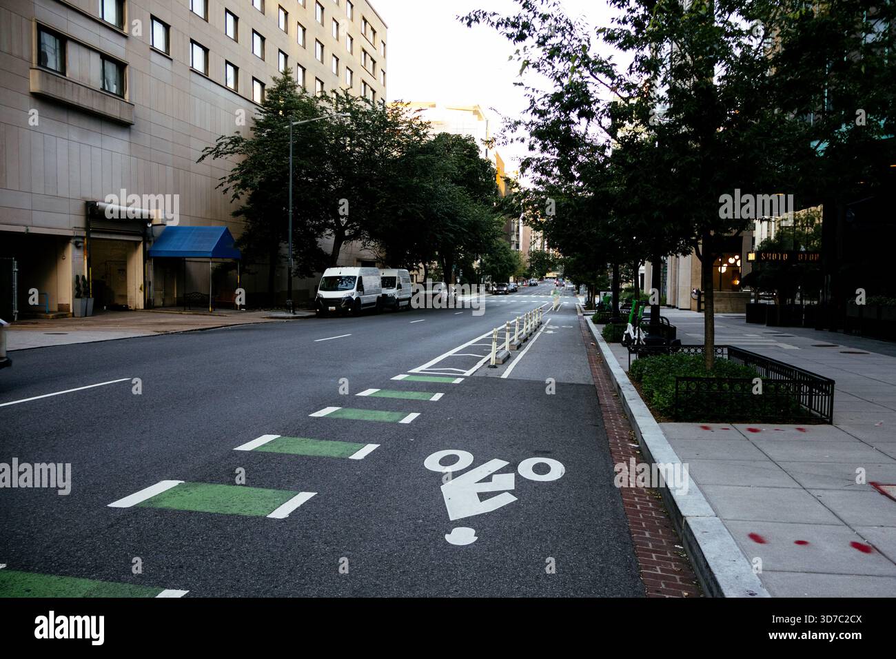 Protected urban bike lane along city street with bollards and cycling ...