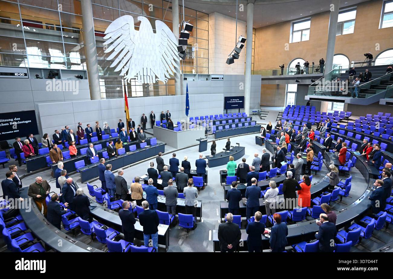 25 November 2025, Berlin: Members of parliament stand at the start of ...