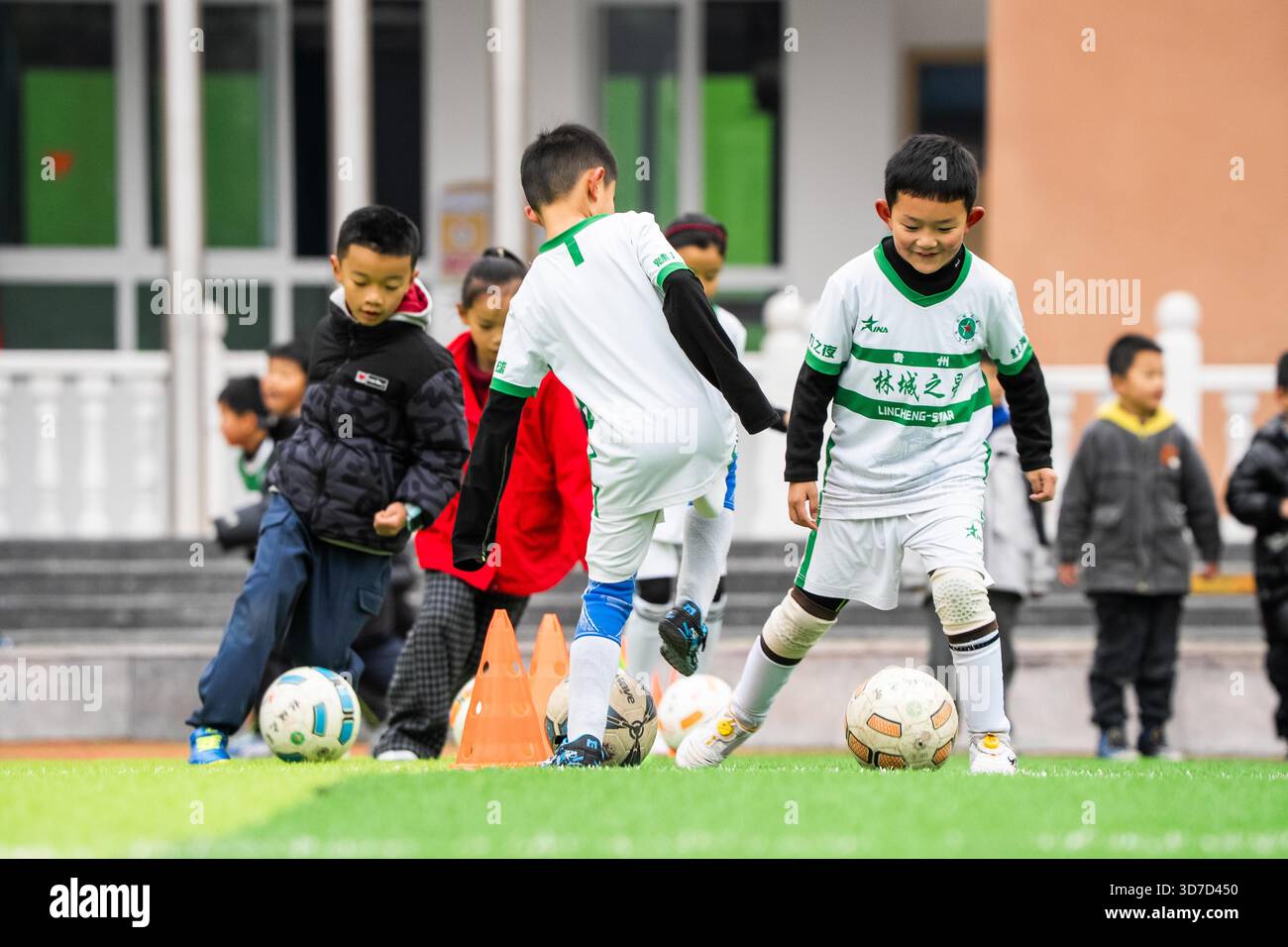Children learn to play football at a shool in Bijie City, southwest ...