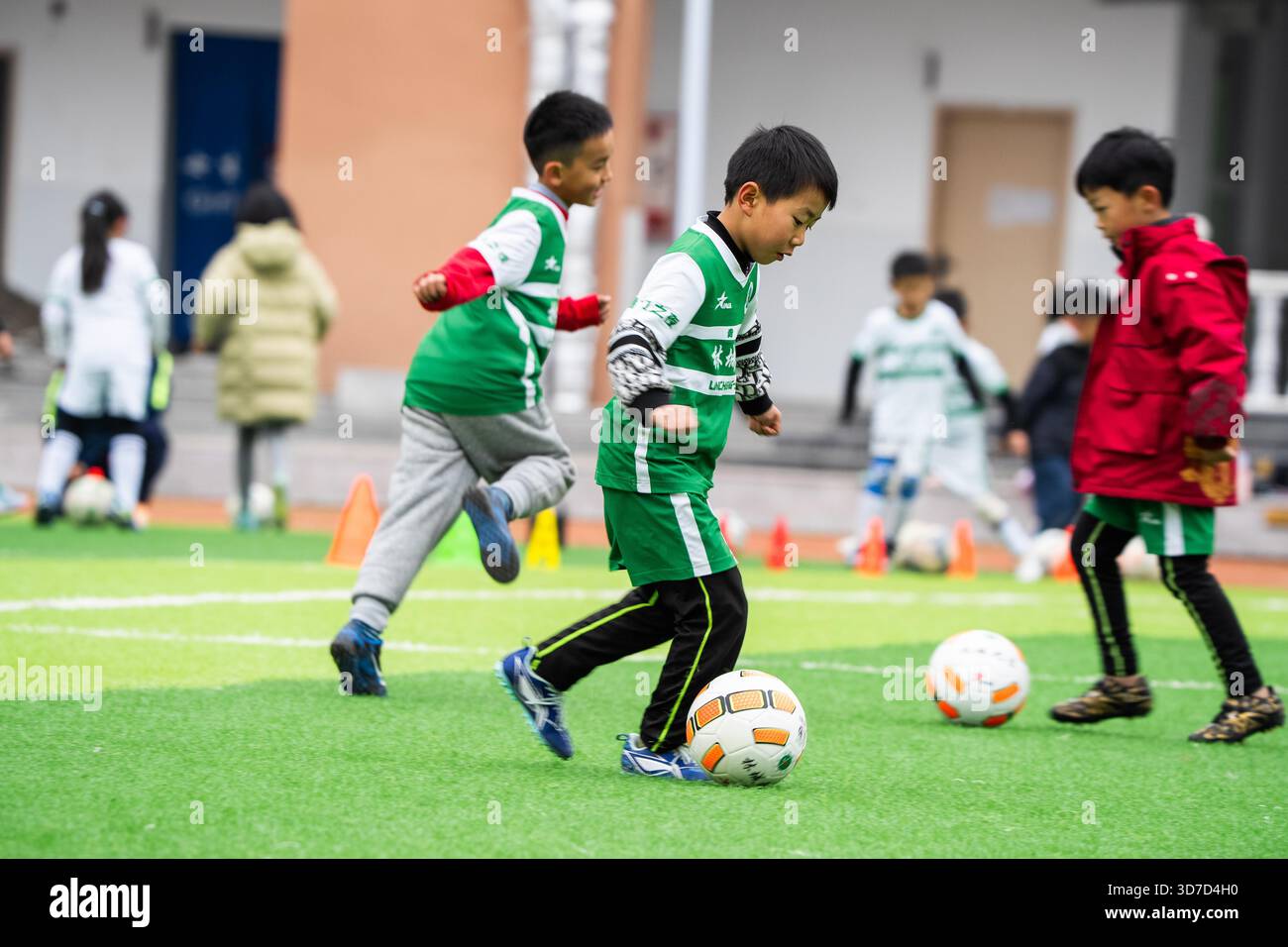 Children learn to play football at a shool in Bijie City, southwest ...