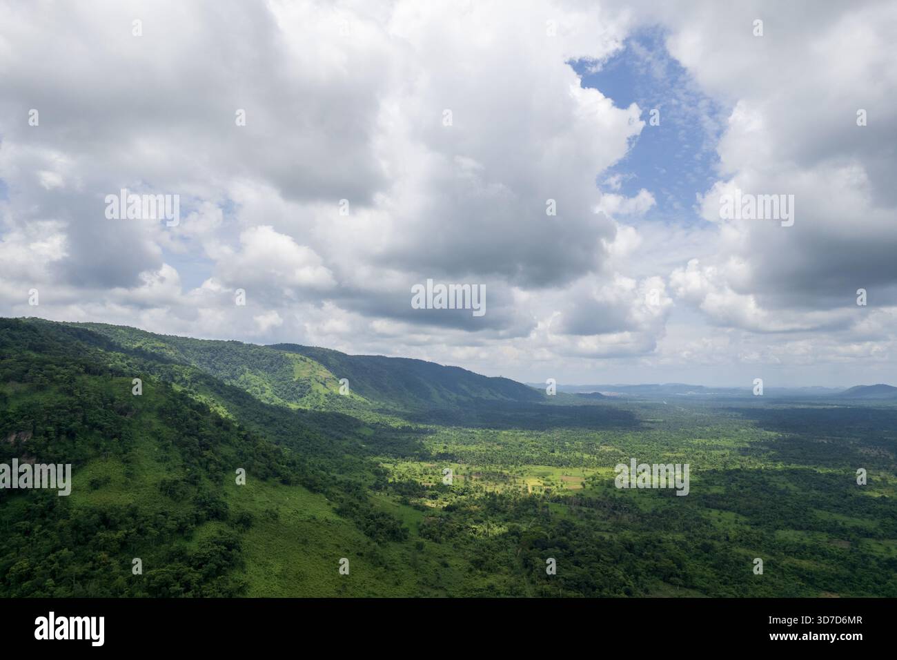 Aerial view of mountains covered in dense green forests under a sky ...
