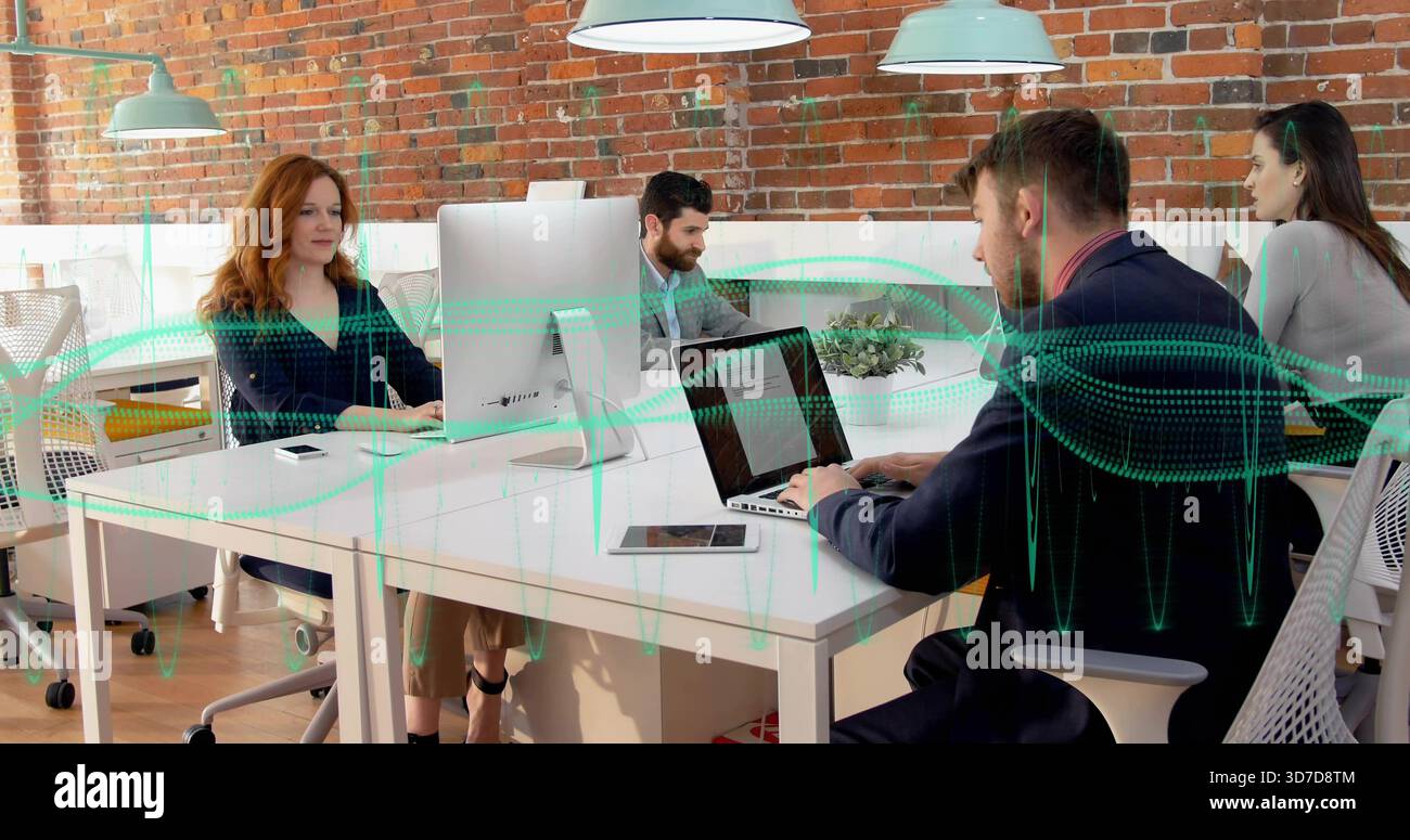 Working team of four in blazers typing and discussing in open-plan ...