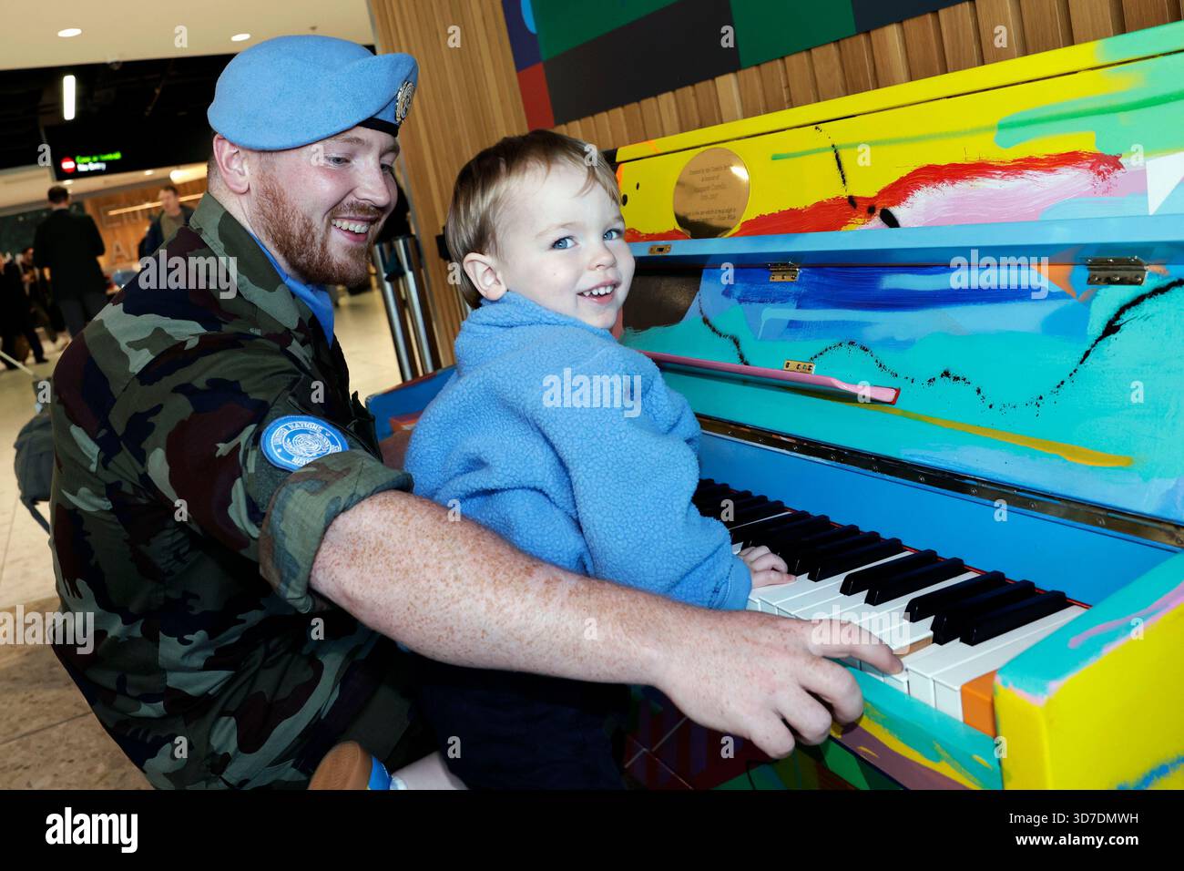 Private Russell Doyle plays the piano with his son, Rian, as they wait ...