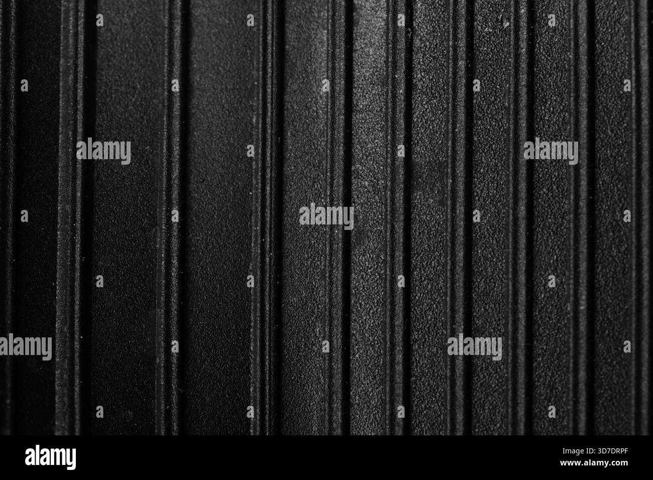 Close-up of black surface featuring evenly spaced vertical ridges ...