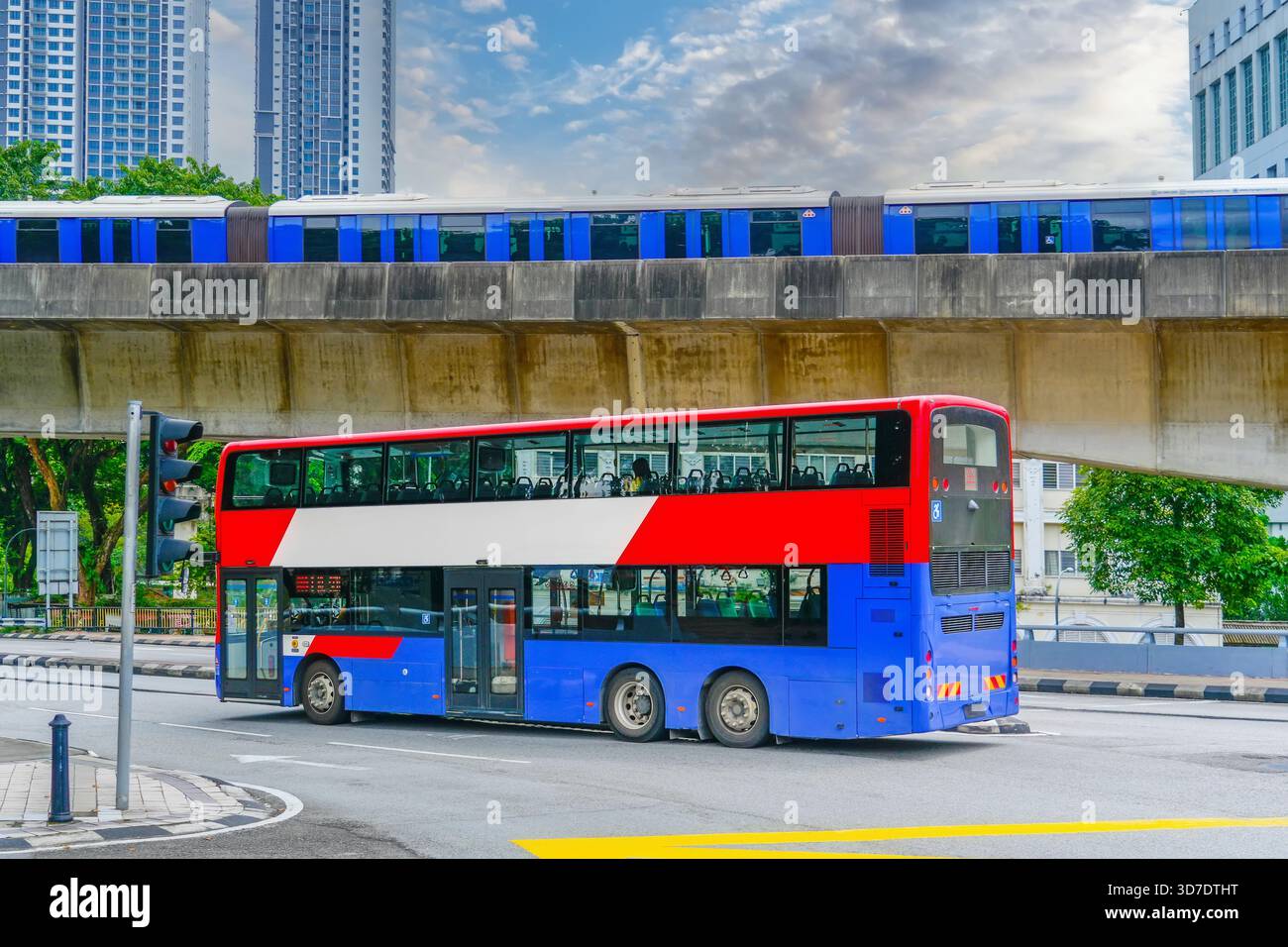 Double-decker city bus travels along a route under a bridge with a ...