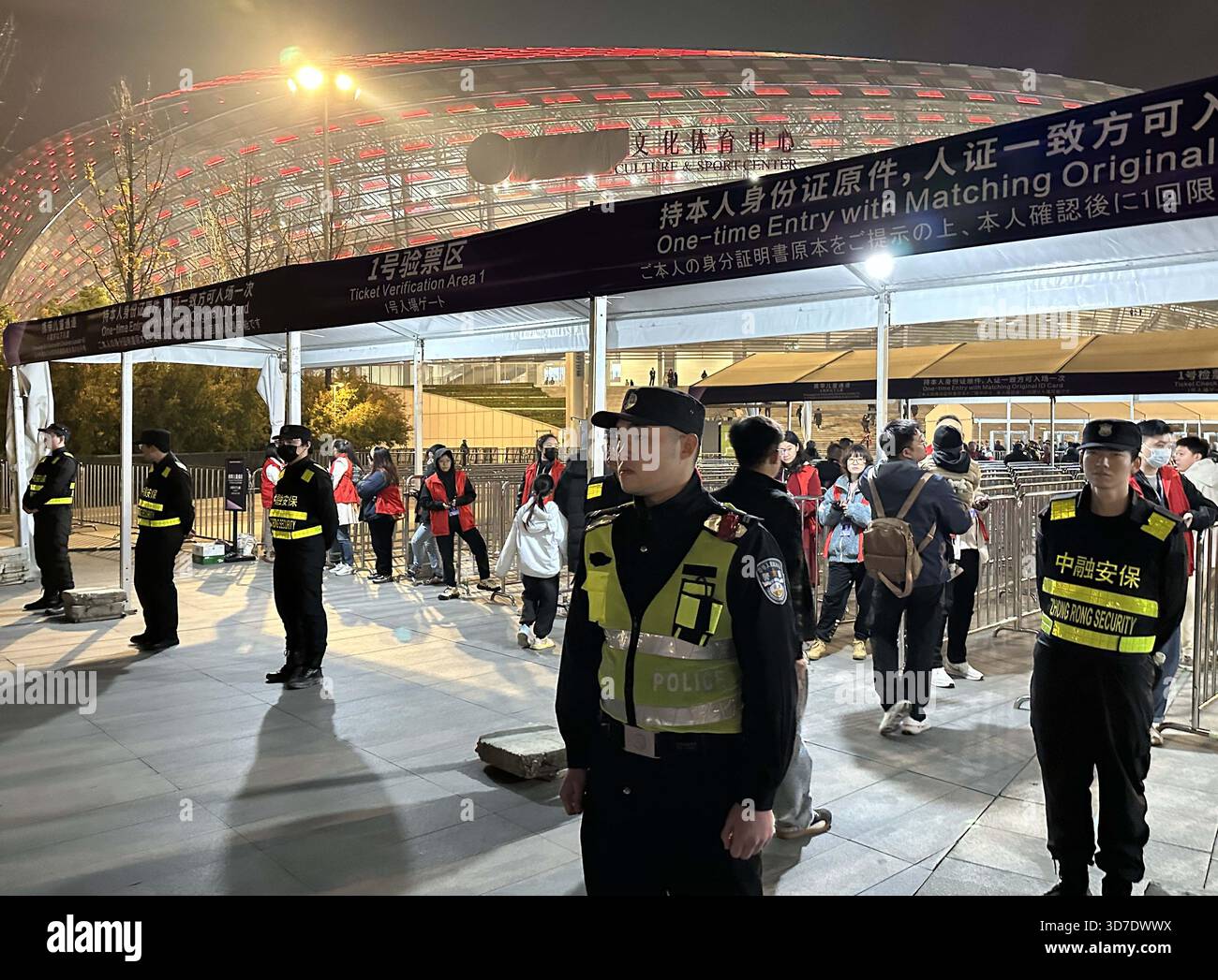 Police officers stand guard around the stadium, where an Asian ...