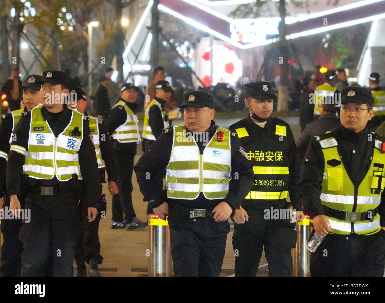 Police officers stand guard around the stadium, where an Asian ...