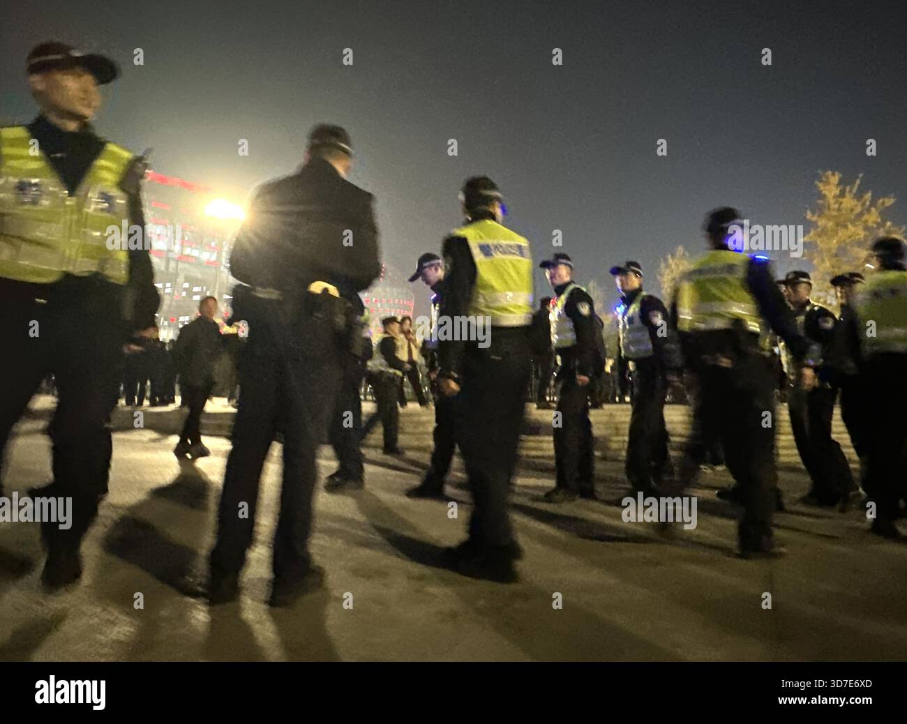 Police officers stand guard around the stadium, where an Asian ...