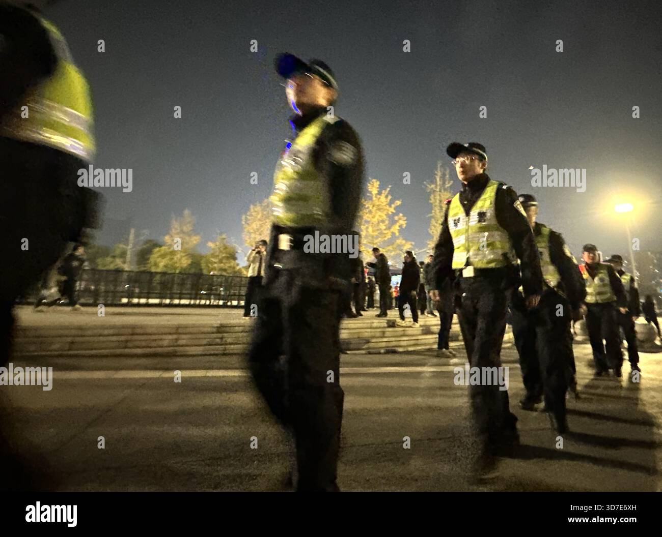 Police officers stand guard around the stadium, where an Asian ...