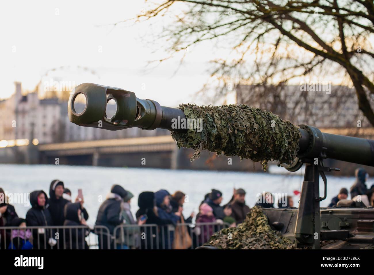 Camouflaged NATO tank gun barrel and turret-mounted weapon system shown ...