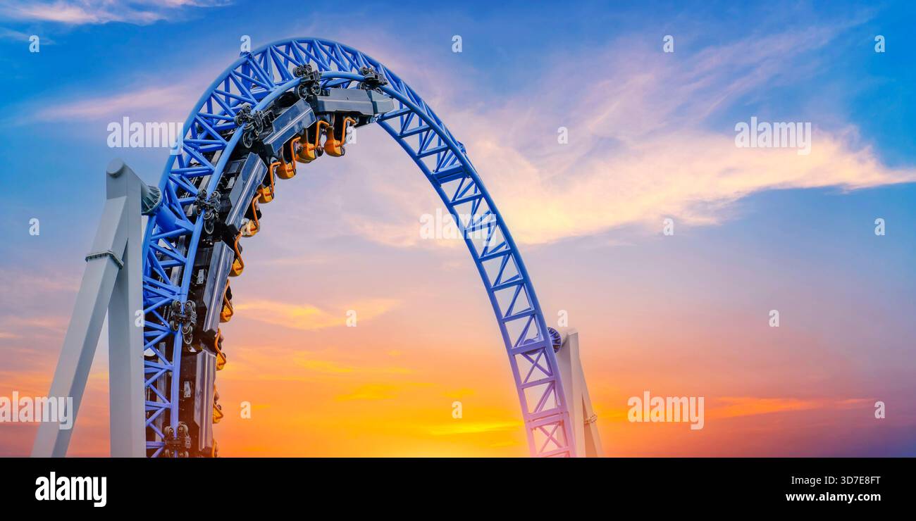 Roller coaster cart and people riding it goes through a loop upside ...
