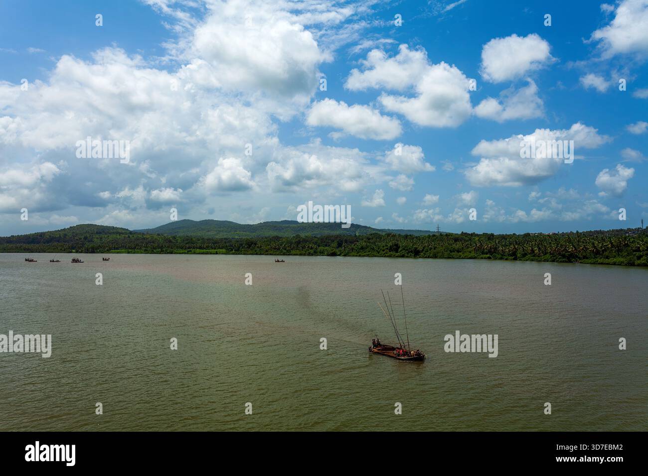 Manually offloading sand from a boat on the Mandovi River in Goa, India ...