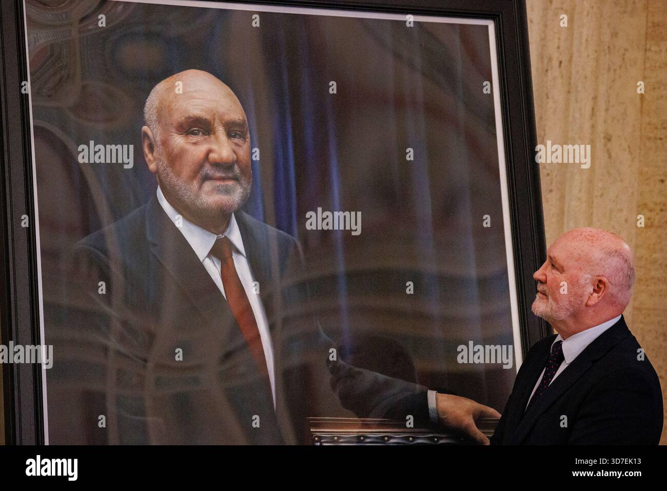 Former Stormont speaker Alex Maskey looks at a portrait of him by ...