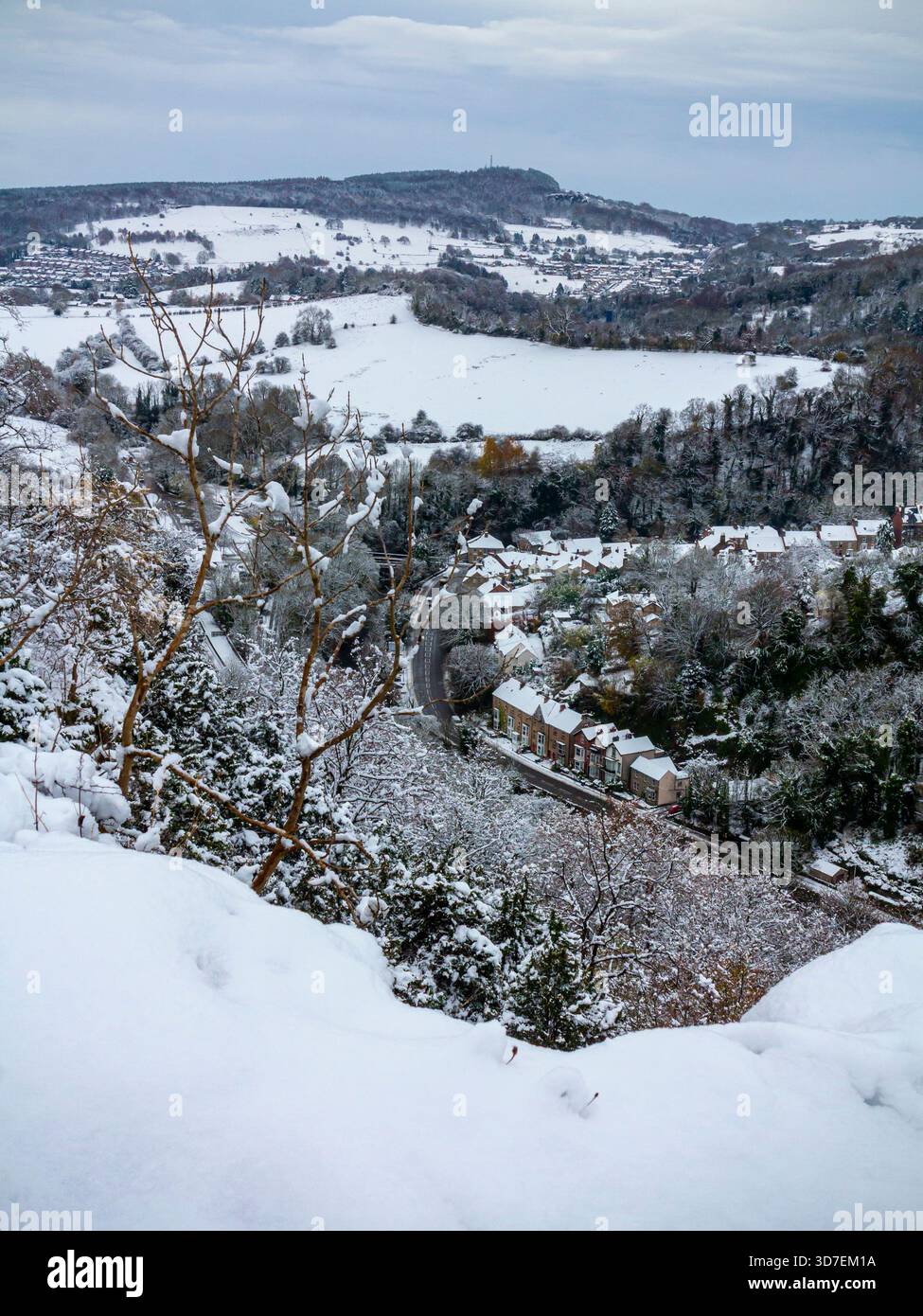 Snow covered landscape with trees and houses seen from High Tor at ...