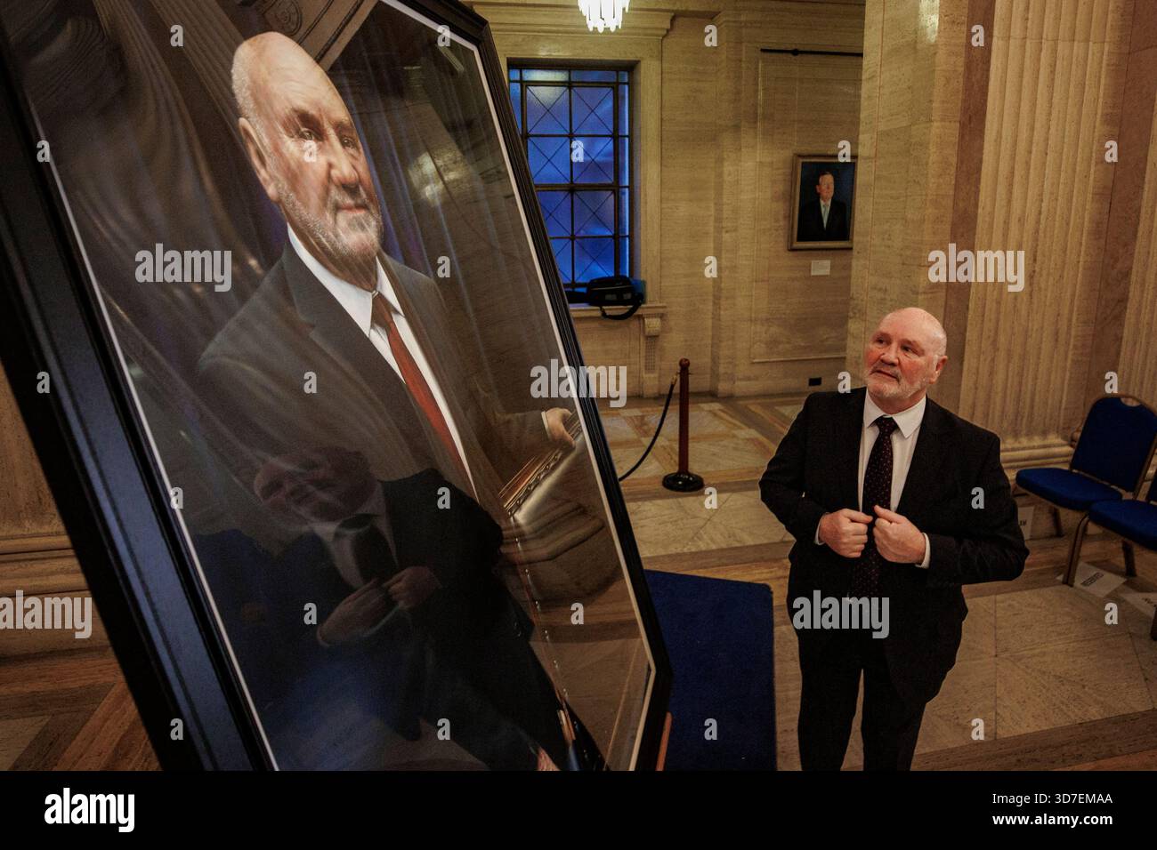 Former Stormont speaker Alex Maskey in front of a portrait of him by ...