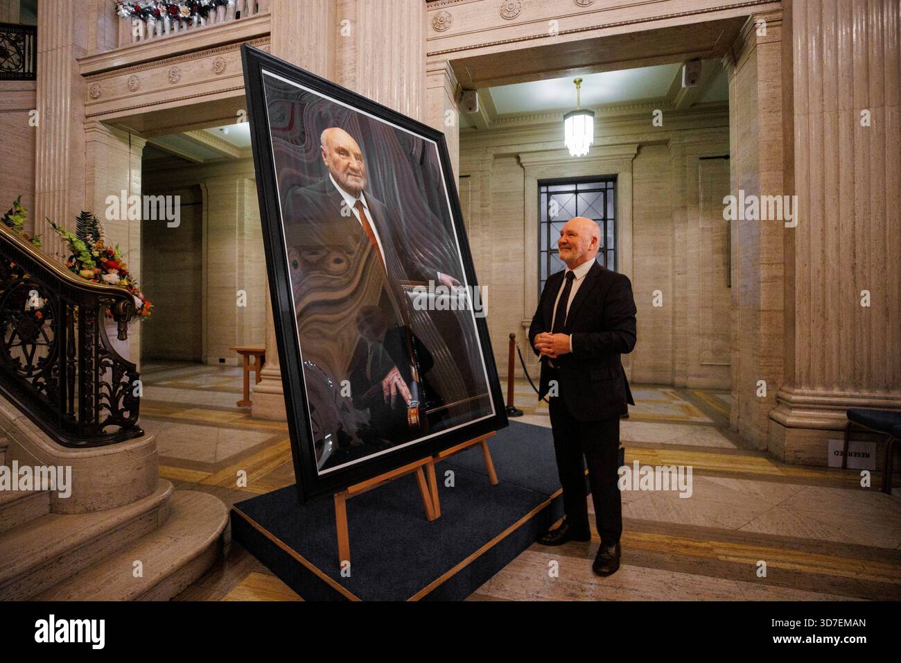 Former Stormont speaker Alex Maskey in front of a portrait of him by ...