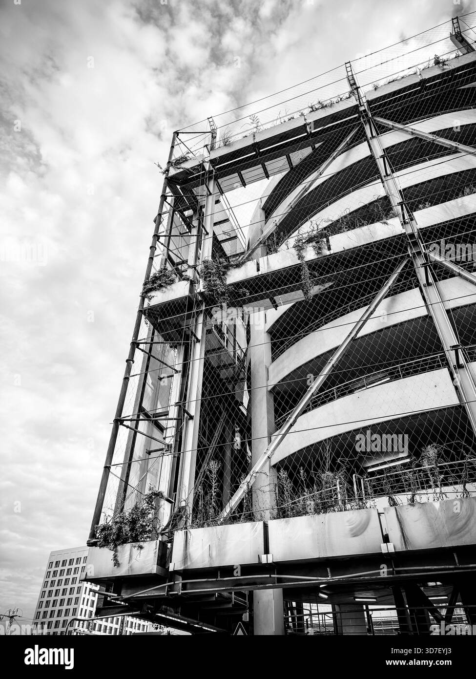 Modern steel parking structure with exposed framing and curved ramps in ...