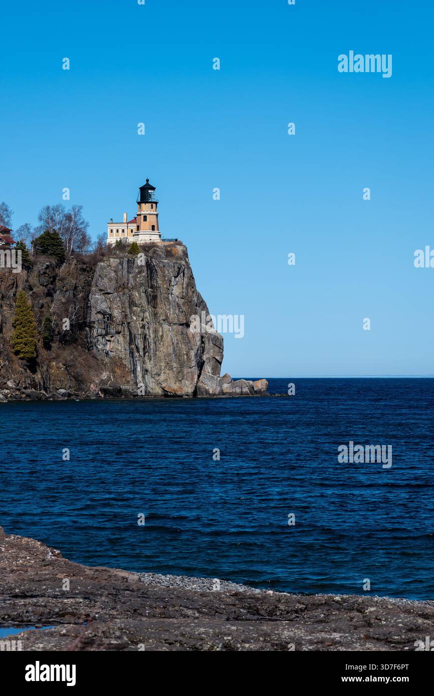 A portrait oriented image of the Split Rock Lighthouse atop a rock ...