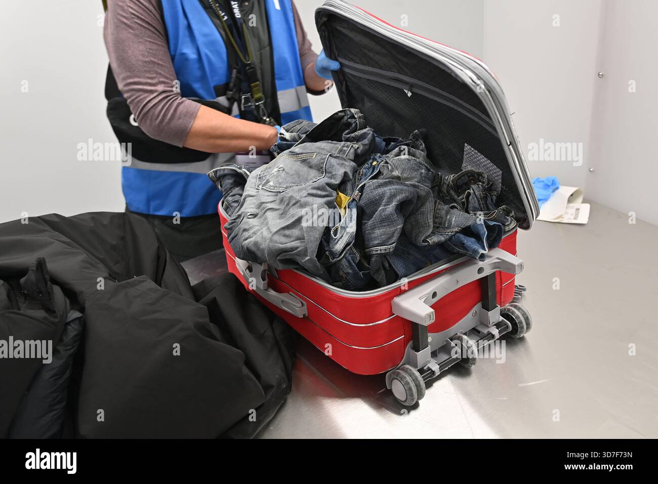A suitcase is being opened and searched by a customs officer, Customs ...
