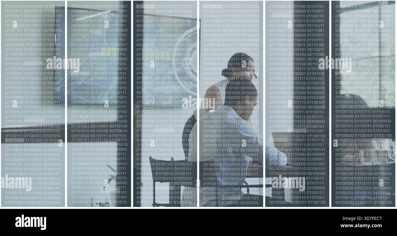 Working office workers in business attire typing at desks behind glass ...