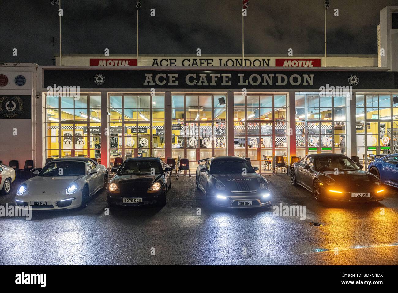 A line of various Porsche models parked outside the iconic Ace Cafe ...