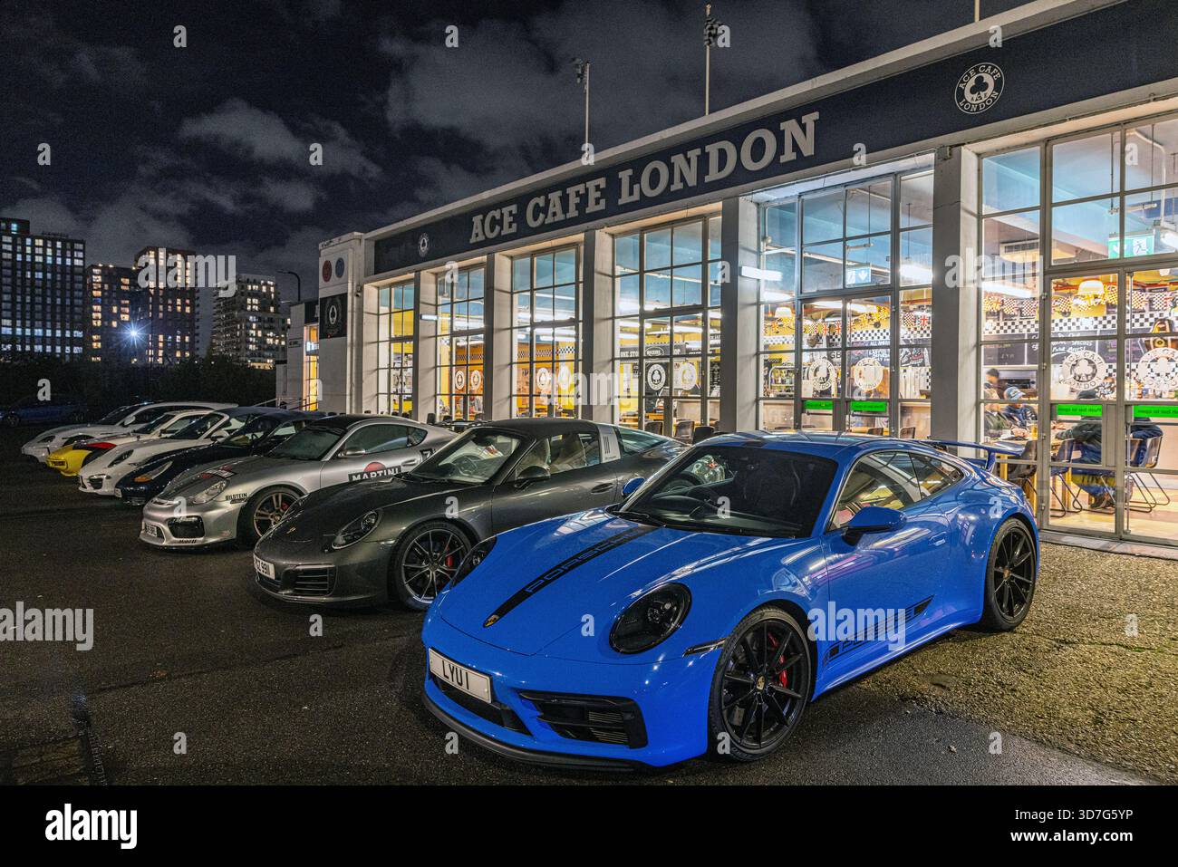 A line of various Porsche models parked outside the iconic Ace Cafe ...