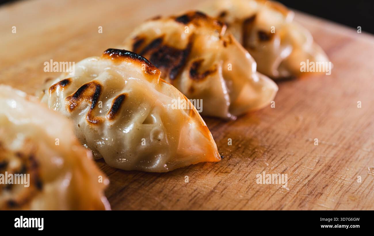 Beautiful golden gyozas perfectly arranged on a plate. Crispy bottom ...