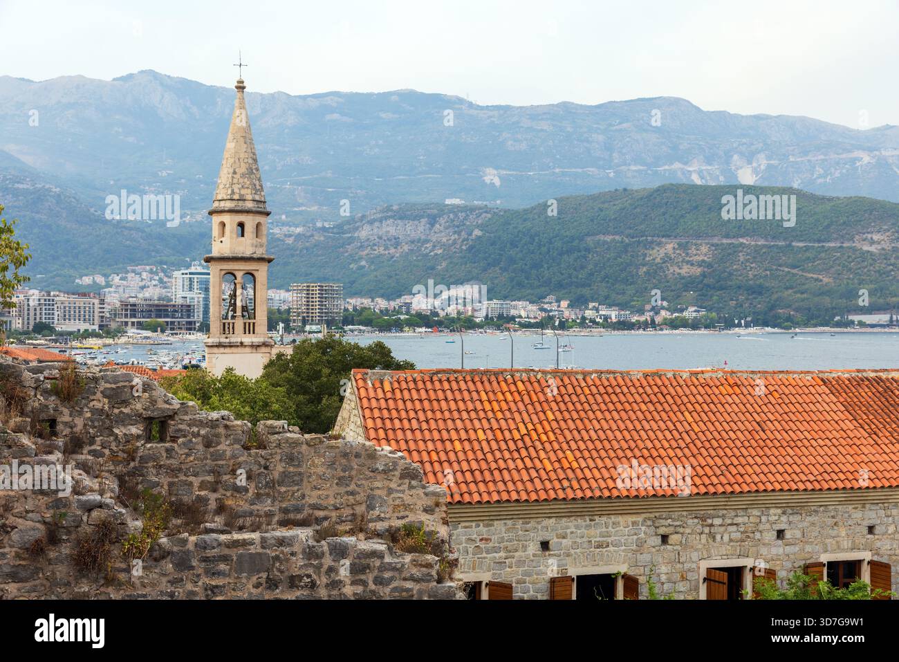 A scenic old town scene featuring a historic stone building with a red ...