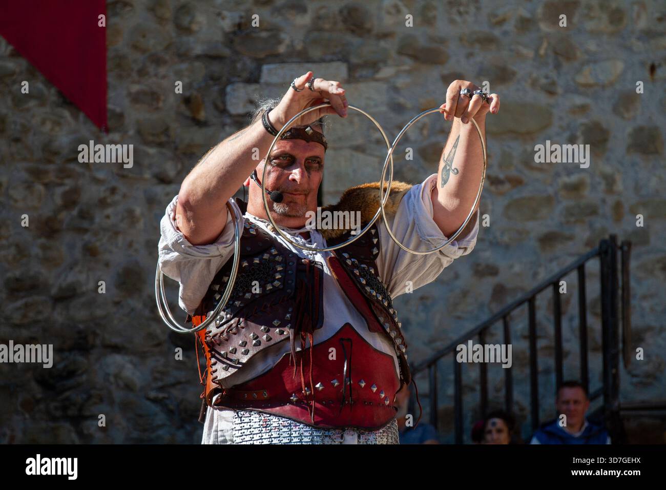 Medieval street performer demonstrating a ring magic trick during a ...